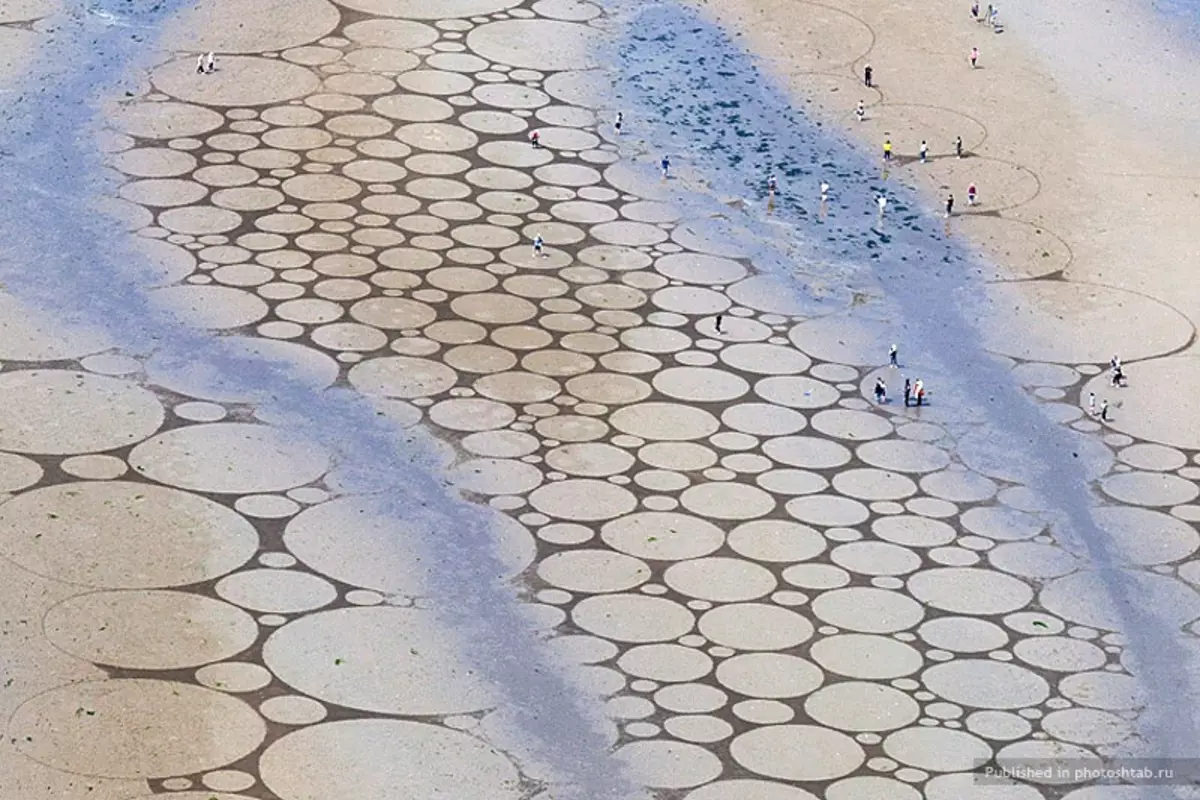 Artisti che disegnano sulla sabbia