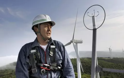 Laboristo ĉe la supro de la turo de la vento-generatoro en Higashi Dori, Japanio