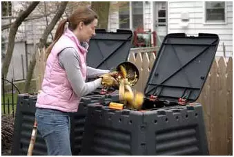 Jennifer Jensen, Magister Program Kompos, mengguncang limbah makanan dari wadah, yang dia simpan di dapur ke dalam tangki kompos di halaman rumahnya di Larchmont, AS